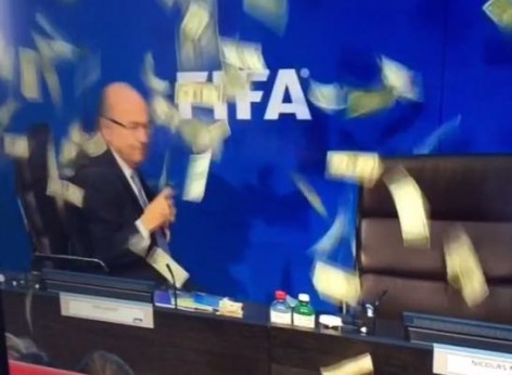 Sepp Blatter has fake money thrown at him during press conference